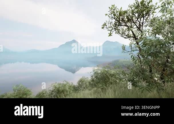 Calm lakeshore scene at sunrise showing misty blue mountain ridges in ...