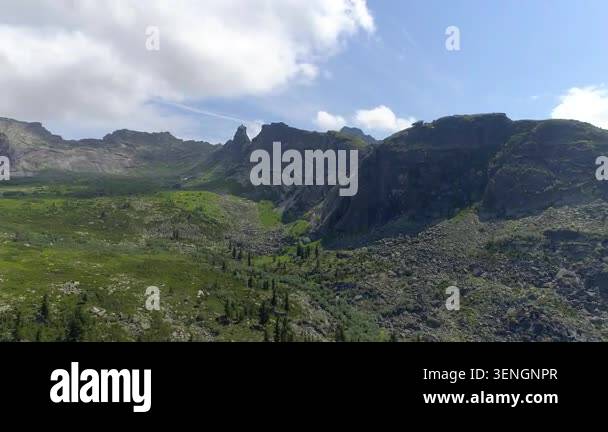 Aerial drone footage flying backwards over a vast and rugged mountain ...