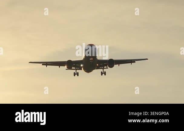 Passenger airplane approaches runway for landing during golden hour ...