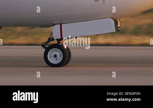Close detail of aircraft main landing gear wheel rolling along runway ...