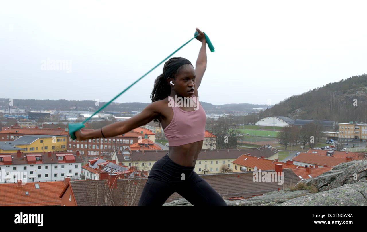 Athletic Young Woman Stretching with Resistance Band Over City View ...