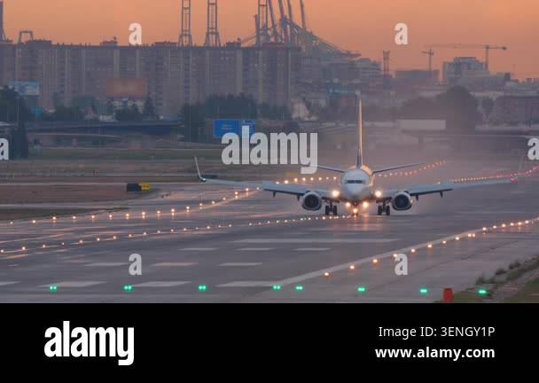 Narrow body passenger jet rolling head on along the runway under a ...