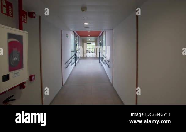 Long empty corridor inside a modern building with handrails on both ...