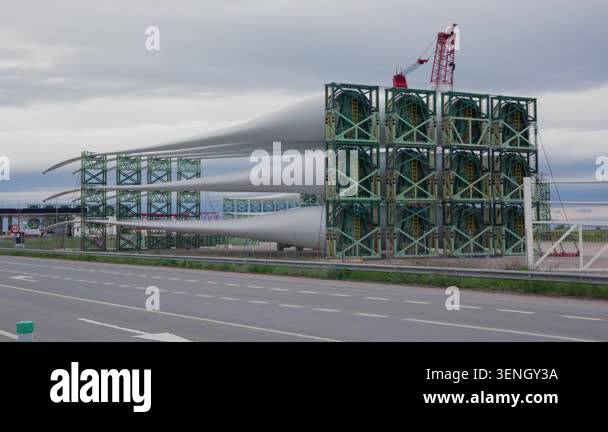 Large white wind turbine blades stacked on green steel storage racks ...