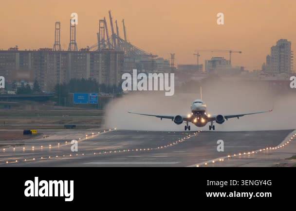 Twin engine passenger jet throwing a cloud of mist and vapor behind it ...