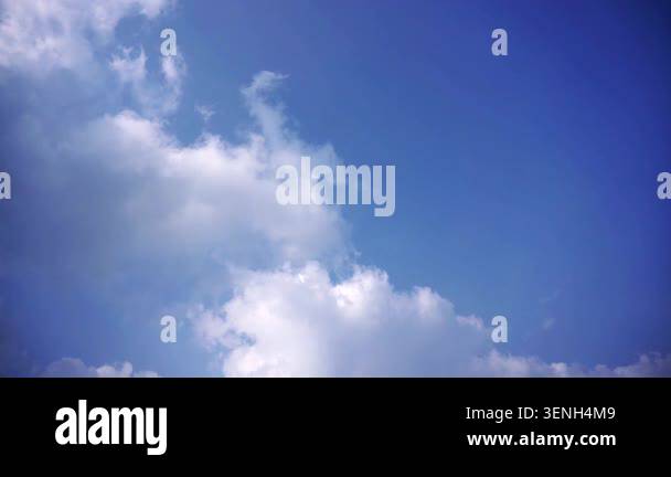 Time-lapse video of white clouds moving fast across a bright blue sky ...