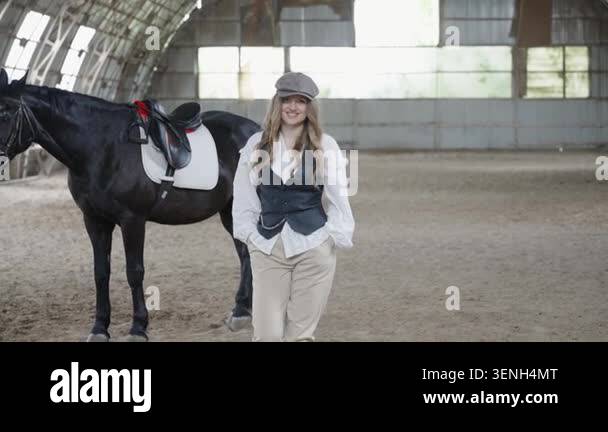 Confident young female jockey posing with black horse Stock Video ...