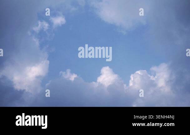 Time-lapse video of white clouds moving fast across a bright blue sky ...