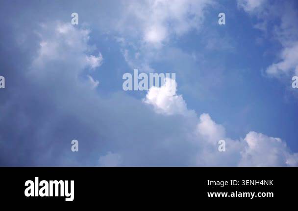 Time-lapse video of white clouds moving fast across a bright blue sky ...