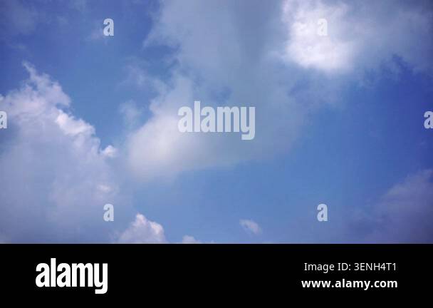 Time-lapse video of white clouds moving fast across a bright blue sky ...