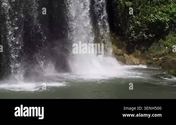 Crystal-clear emerald water rushes down a stunning natural cascade ...