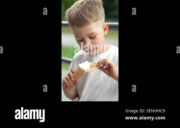 Cute blue eyed boy enjoying ice cream cone outside during summer. Child ...