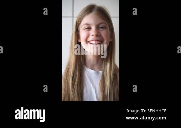 Vertical portrait video of a blonde child laughing naturally on a clean ...