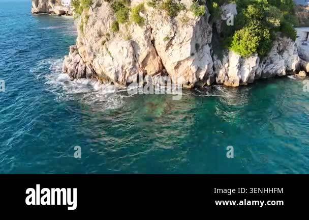 Aerial view of rocky coastline with turquoise sea water gently lapping ...