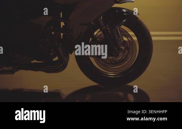 Close up of a front wheel of motorcycle moving on the evening city ...