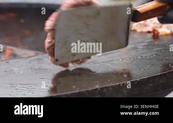 Fresh raw minced beef burger patty sizzling on a hot circular steel ...