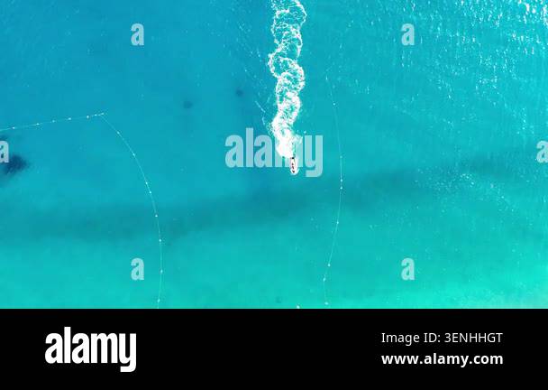 Aerial view of jet ski floating across the vibrant blue sea, creating ...
