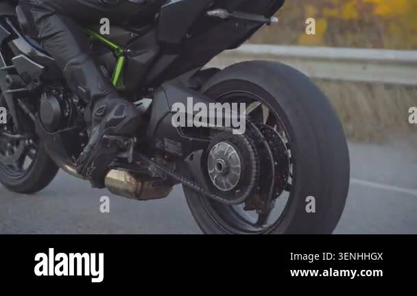 Close up of a back wheel of sport bike moving on the country asphalt ...