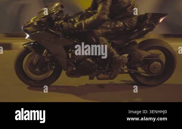 Motorcyclist riding fast on sport motorbike at evening city street ...