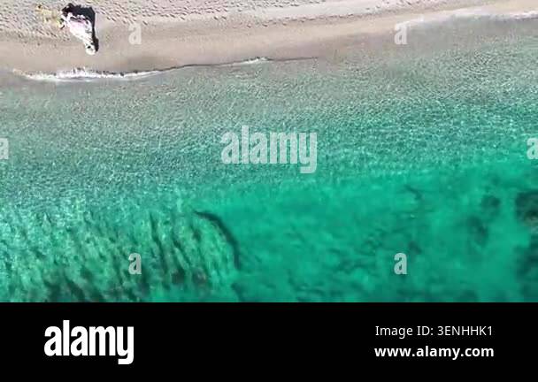 Aerial view of sandy beach with clear turquoise water, showcasing ...
