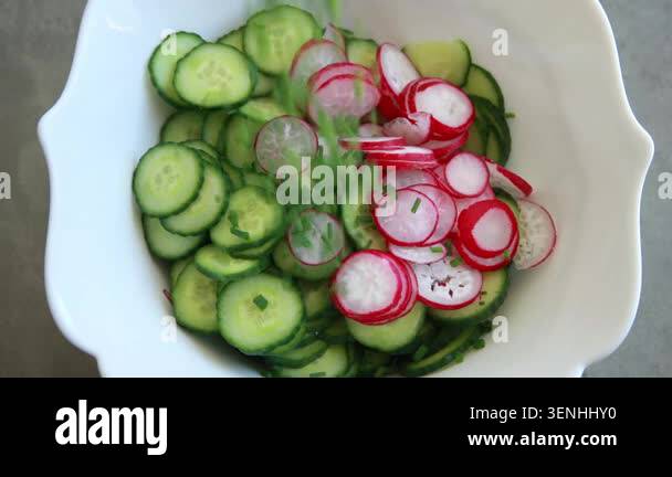 Close-up of fresh sliced cucumbers and vibrant red radishes arranged in ...