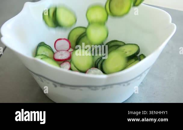 Close-up of fresh sliced cucumbers and vibrant red radishes arranged in ...