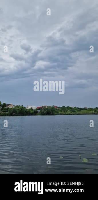 Picturesque summer landscape with a lake in the village under a cloudy ...