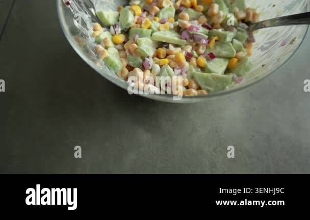 Close-up of a creamy summer salad with sweet corn, crisp cucumber, and ...