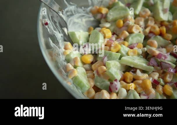 Close-up of a creamy summer salad with sweet corn, crisp cucumber, and ...