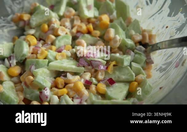 Close-up of a creamy summer salad with sweet corn, crisp cucumber, and ...