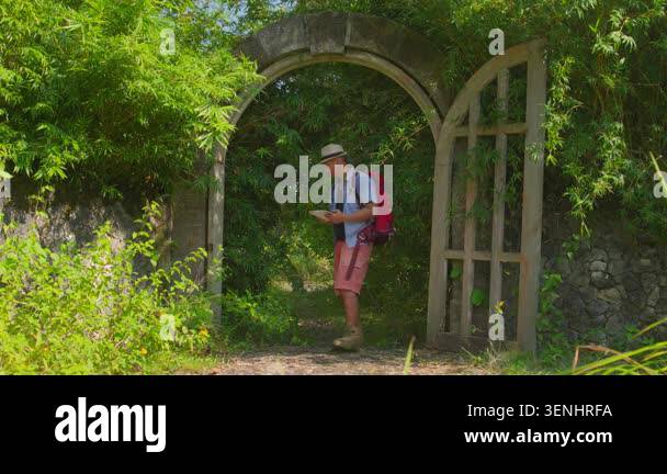 Adventurer Documenting Findings at an Overgrown Historic Gateway ...