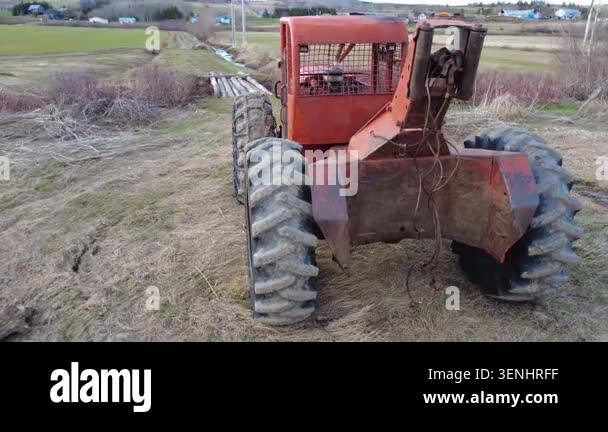 Drone footage of a rusty Timberjack skidder parked beside a stream ...