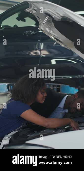 Female car mechanic showing diagnostic codes on a tablet and explains a ...