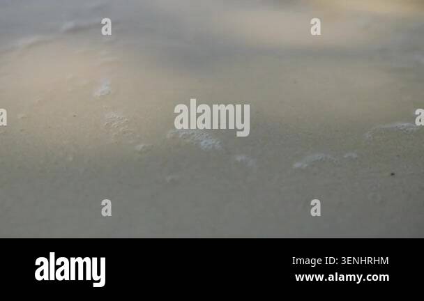 Close-Up of Clear Waves Lapping onto a Clean White Sandy Shore Beneath ...