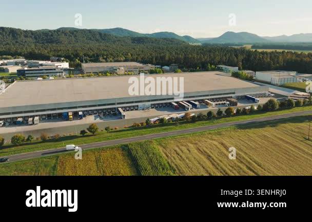 Large logistics center shows trucks loading and unloading cargo in the ...