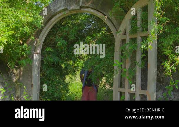 Adventurer Entering an Abandoned Building Through an Old Gate Overtaken ...