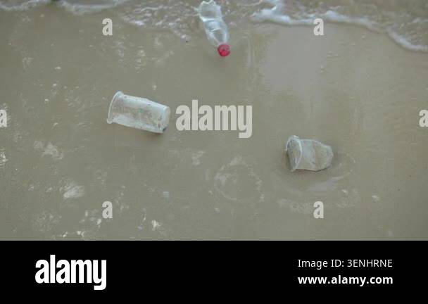 Plastic Waste Floating onto a Beach Shoreline with Incoming Waves ...