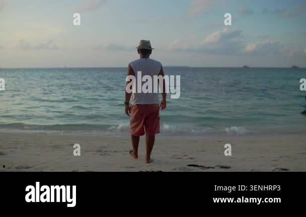 Man Standing on a Tropical Beach with Arms Outstretched, Breathing in ...
