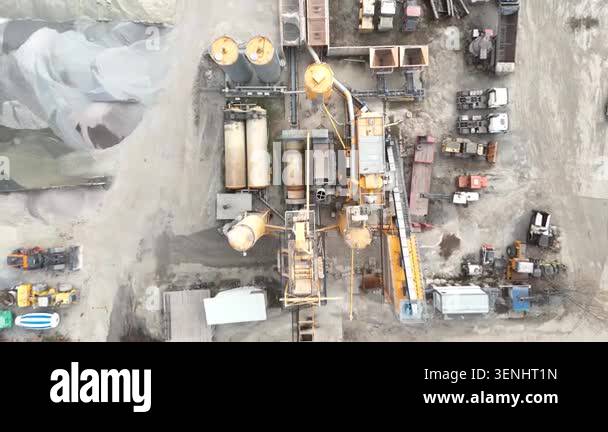 Aerial view of industrial enterprise with machinery, trucks, and ...