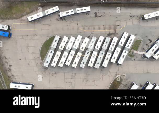 Aerial view of a bus fleet parked in a lot, showcasing a continuous ...