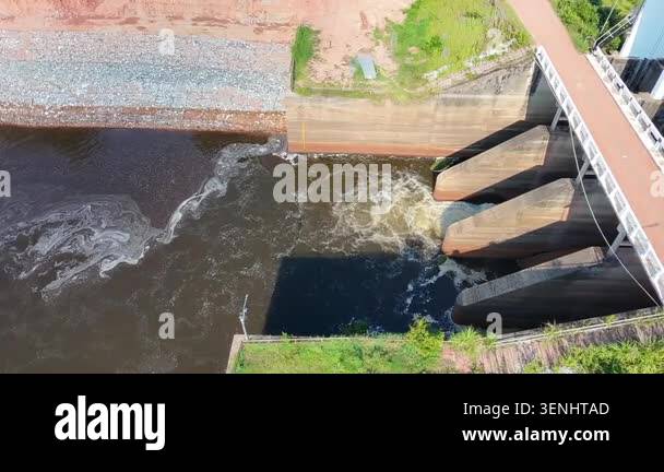 dam on the river, water rushing through concrete dam spillway gates ...