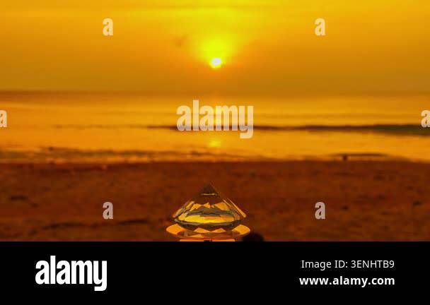 Vibrant sunset colors fill the sky above a peaceful tropical beach as a ...
