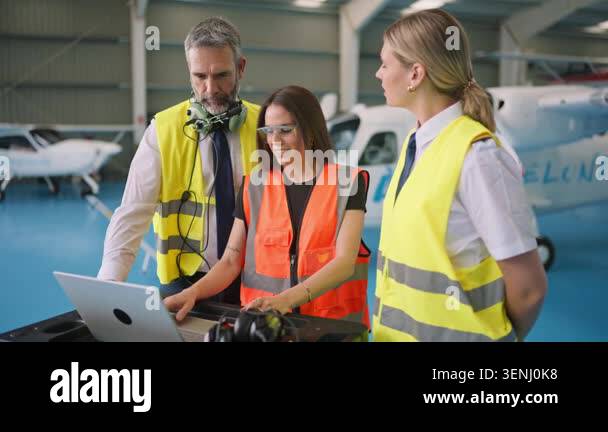 Team of aviation professionals using a laptop for airplane diagnostics ...