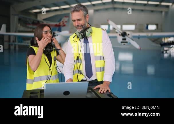 Aviation professionals working together on a laptop inside an aircraft ...