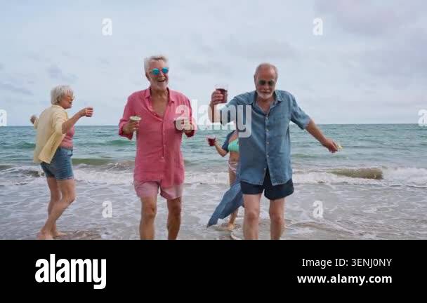 Joyful group of elderly friends happily walking and dancing along the ...