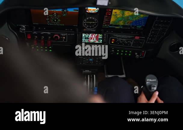 Two pilots cooperating in a modern glass cockpit, manipulating the ...