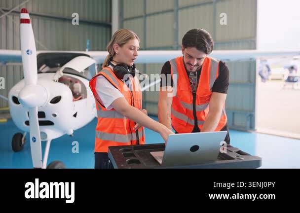 Young male and female aerospace engineers discussing plane maintenance ...