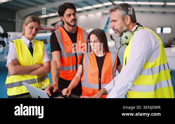 Professional aviation team discussing a project on a laptop inside an ...