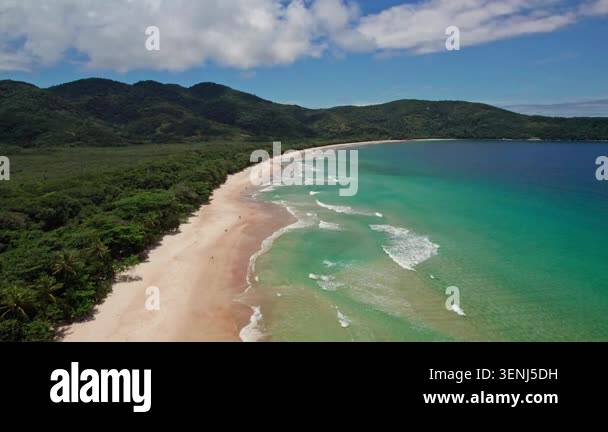 Aerial view of a pristine beach, white sand, turquoise water, and lush ...