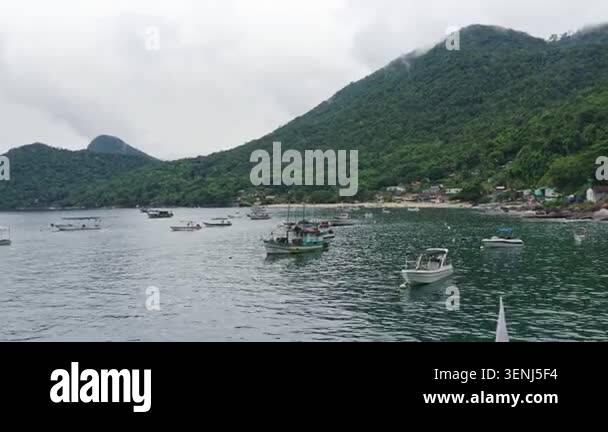 Panoramic view of a coastline with lush mountains, boats on water, and ...